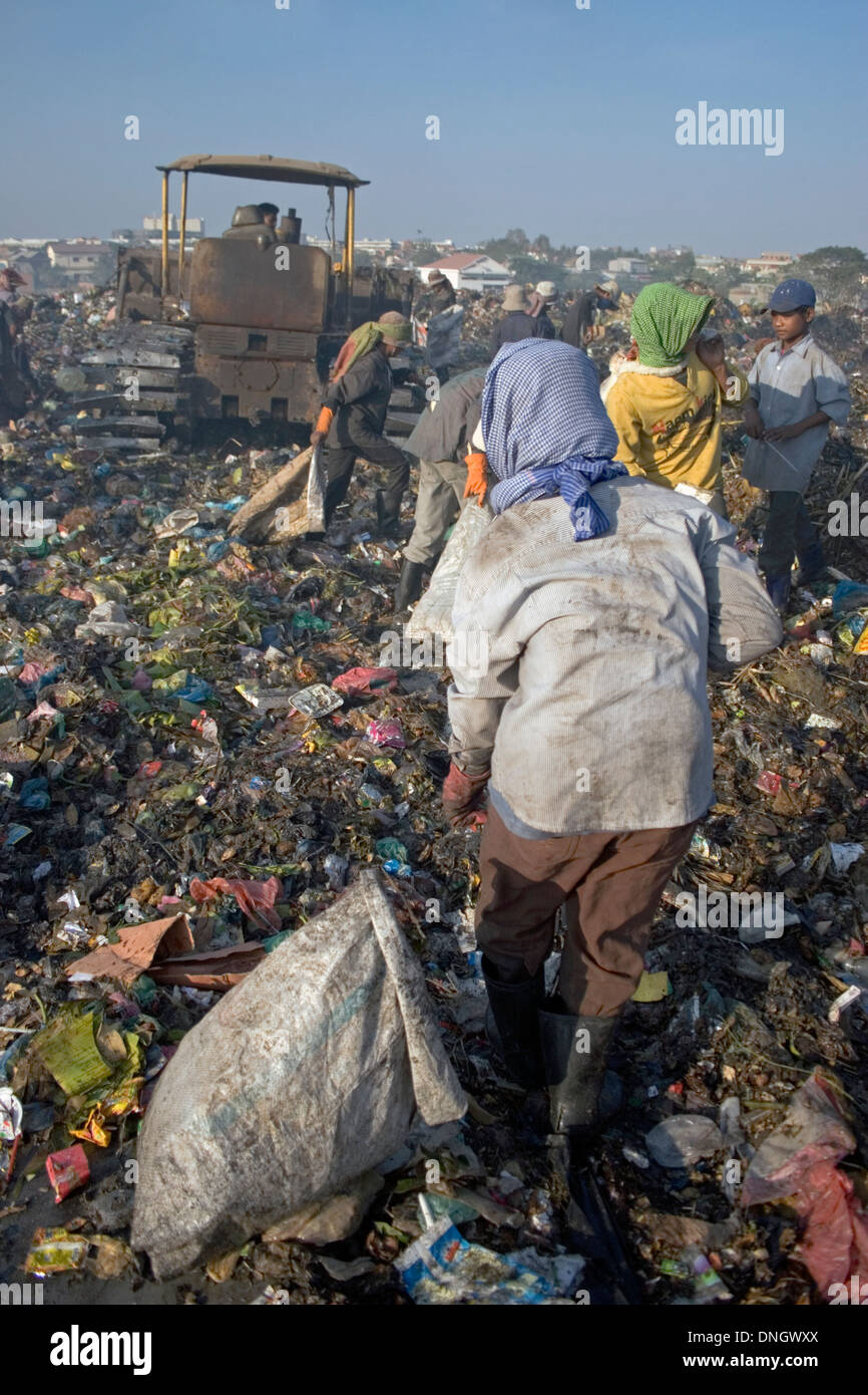 People are collecting recyclable material near a large tractor at the ...