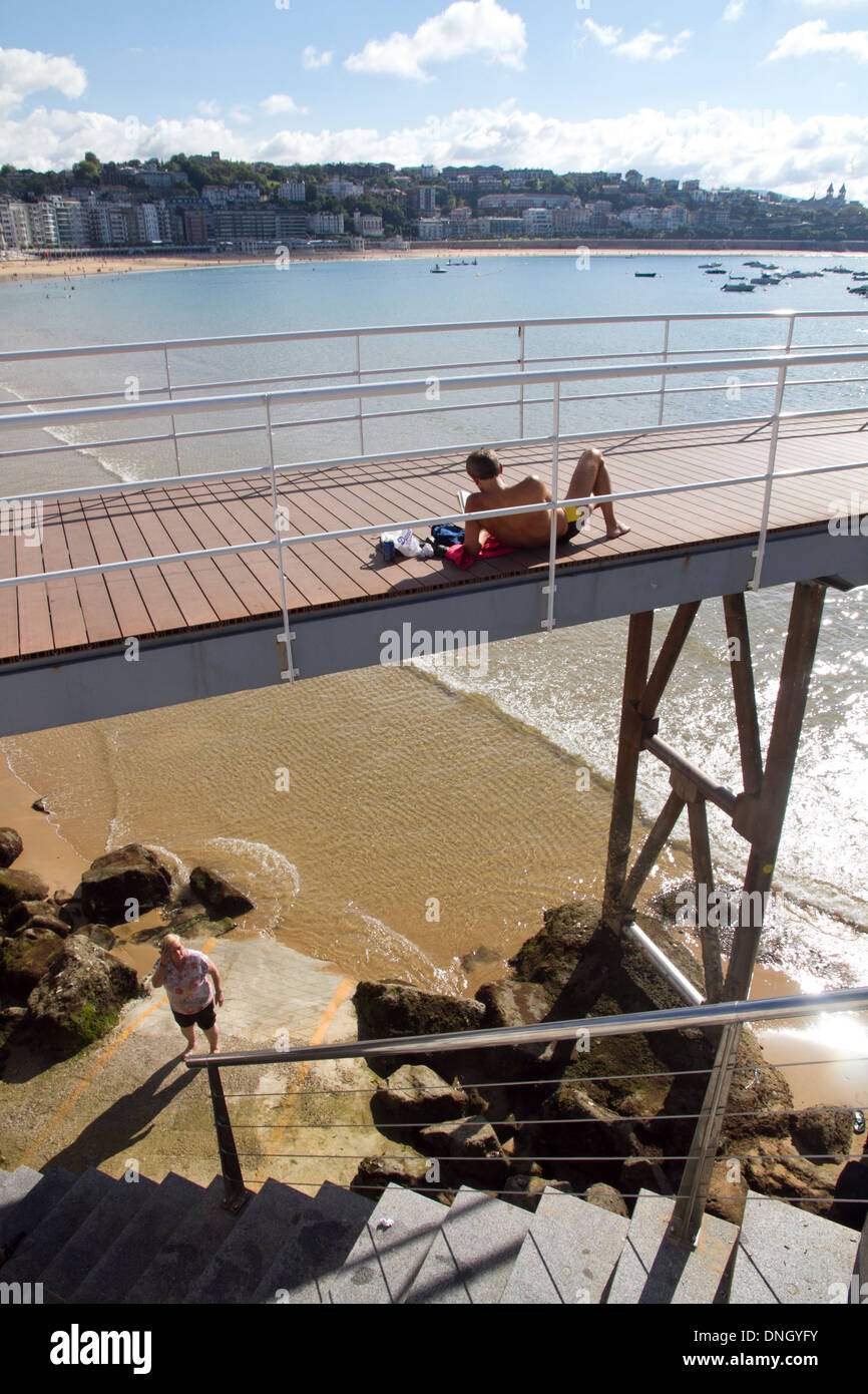 Person reading and sunbathing on bridge in San Sebastian La Concha ...