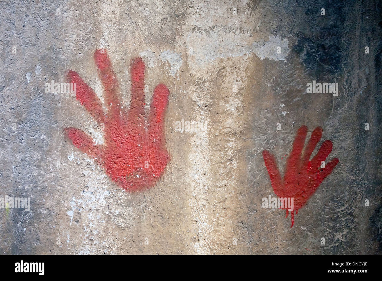 two red hands tracks painted on the grey wall closeup Stock Photo - Alamy