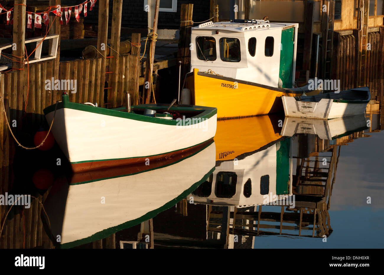 Closeup of small white boat and reflection beside pier Stock Photo - Alamy