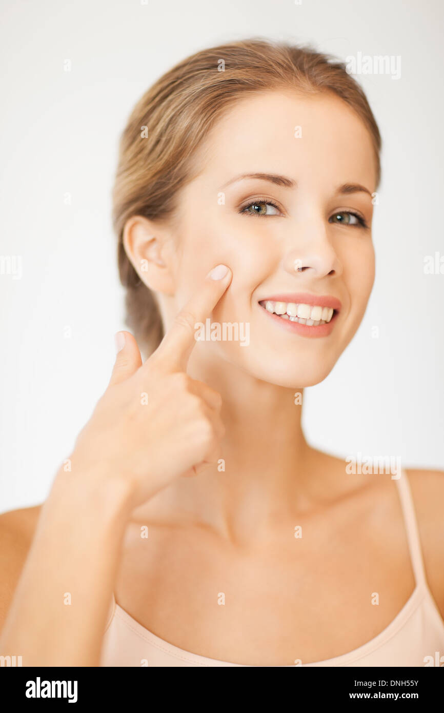 beautiful woman pointing to cheek Stock Photo - Alamy