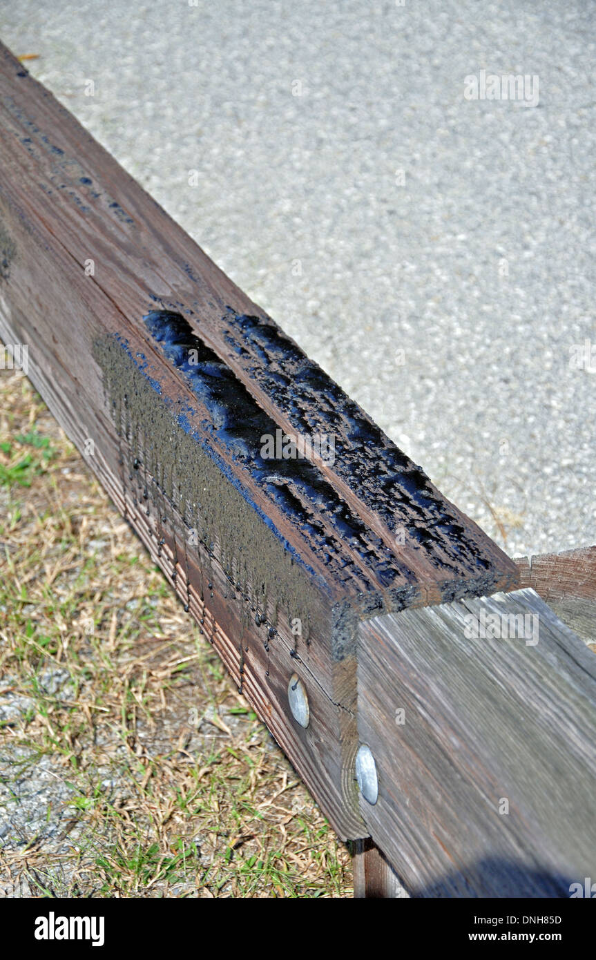 tar seeping out of a pressure treated beam in a road side guard rail ...