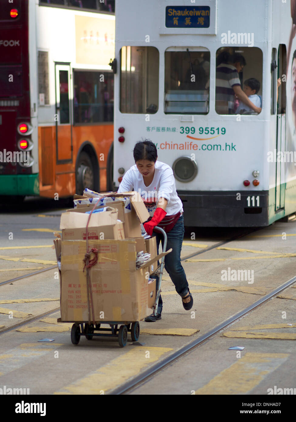 A woman pushes collected used cardboard boxes for recycling Stock Photo ...