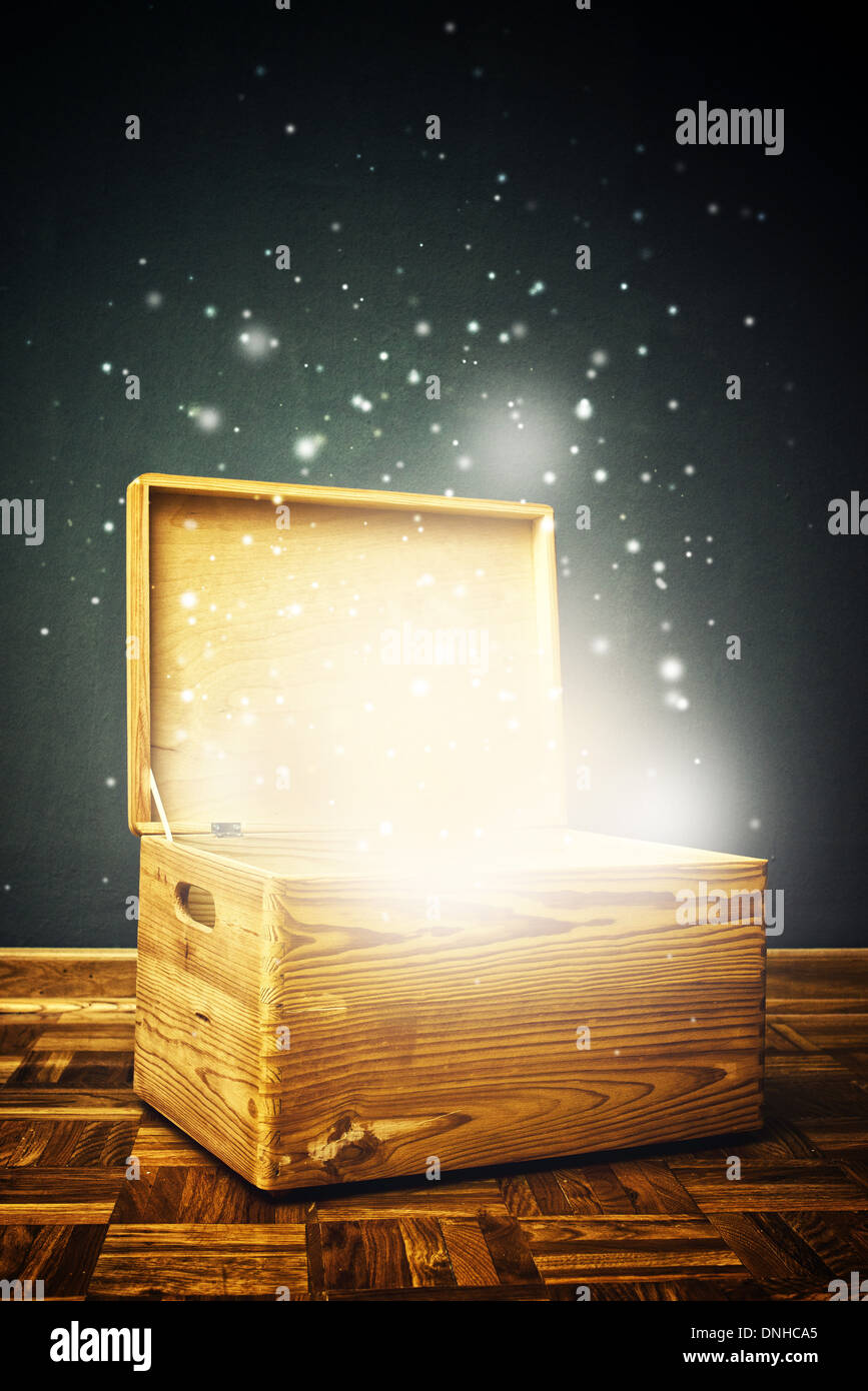 Open magical Wooden crate box on the floor with shiny particles flying ...