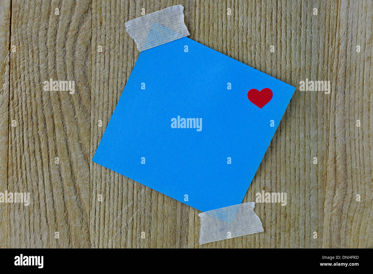 Blue post it note with heart taped to a wooden background Stock Photo ...