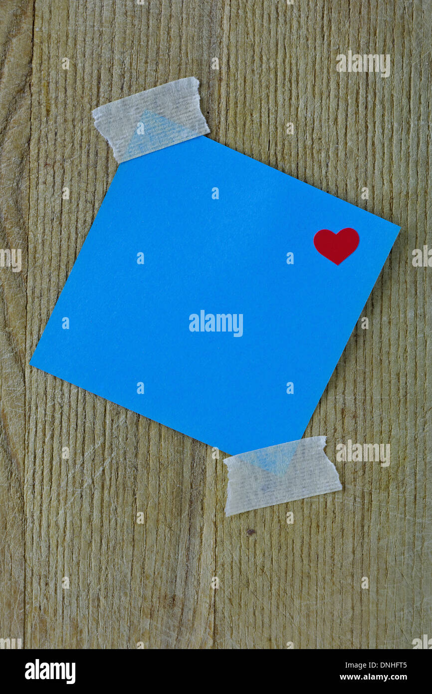 Blue post it note with heart taped to a wooden background Stock Photo ...