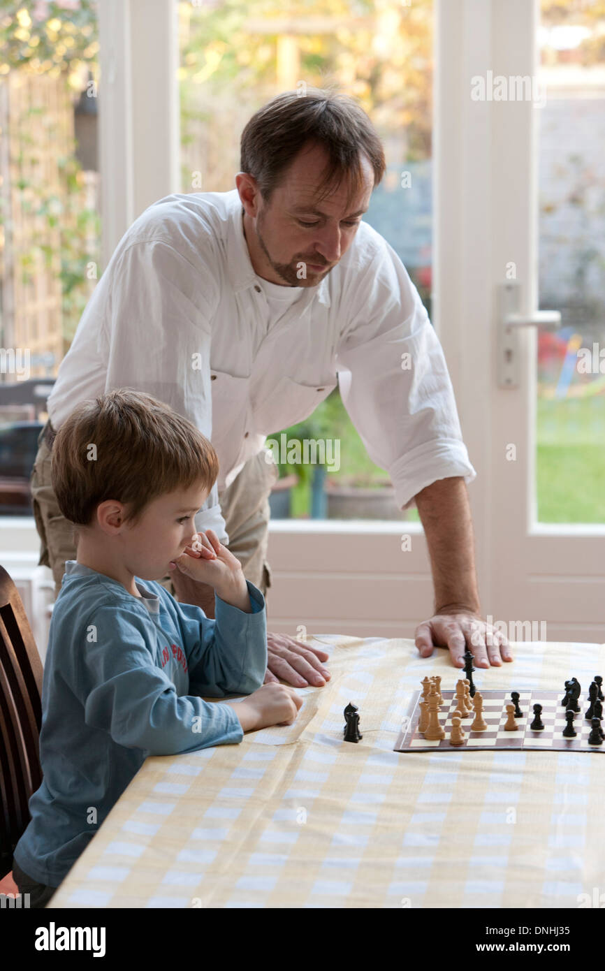 Father is playing chess with his son in the kitchen Stock Photo - Alamy