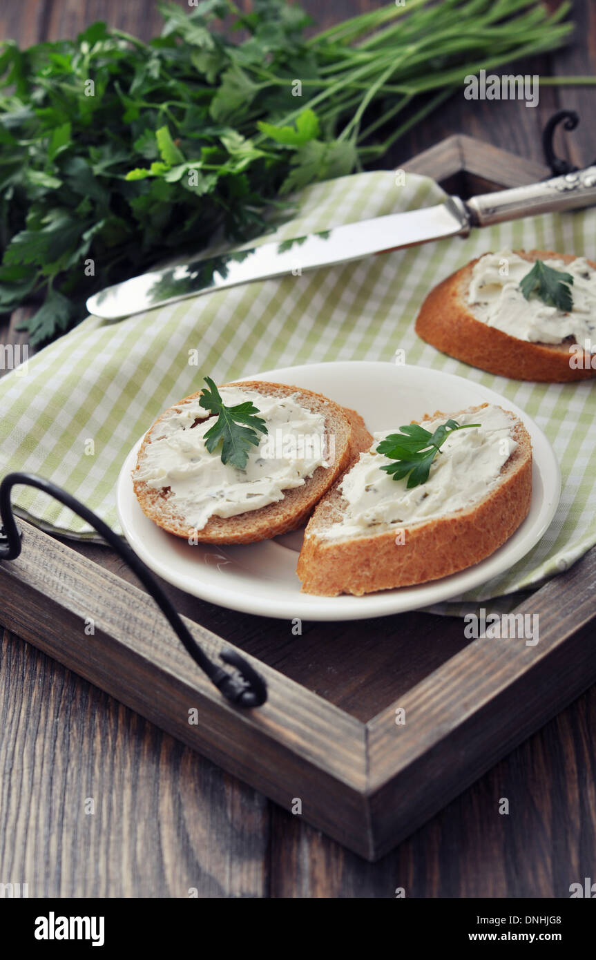 Slice of bread with cream cheese on vintage tray on wooden background ...