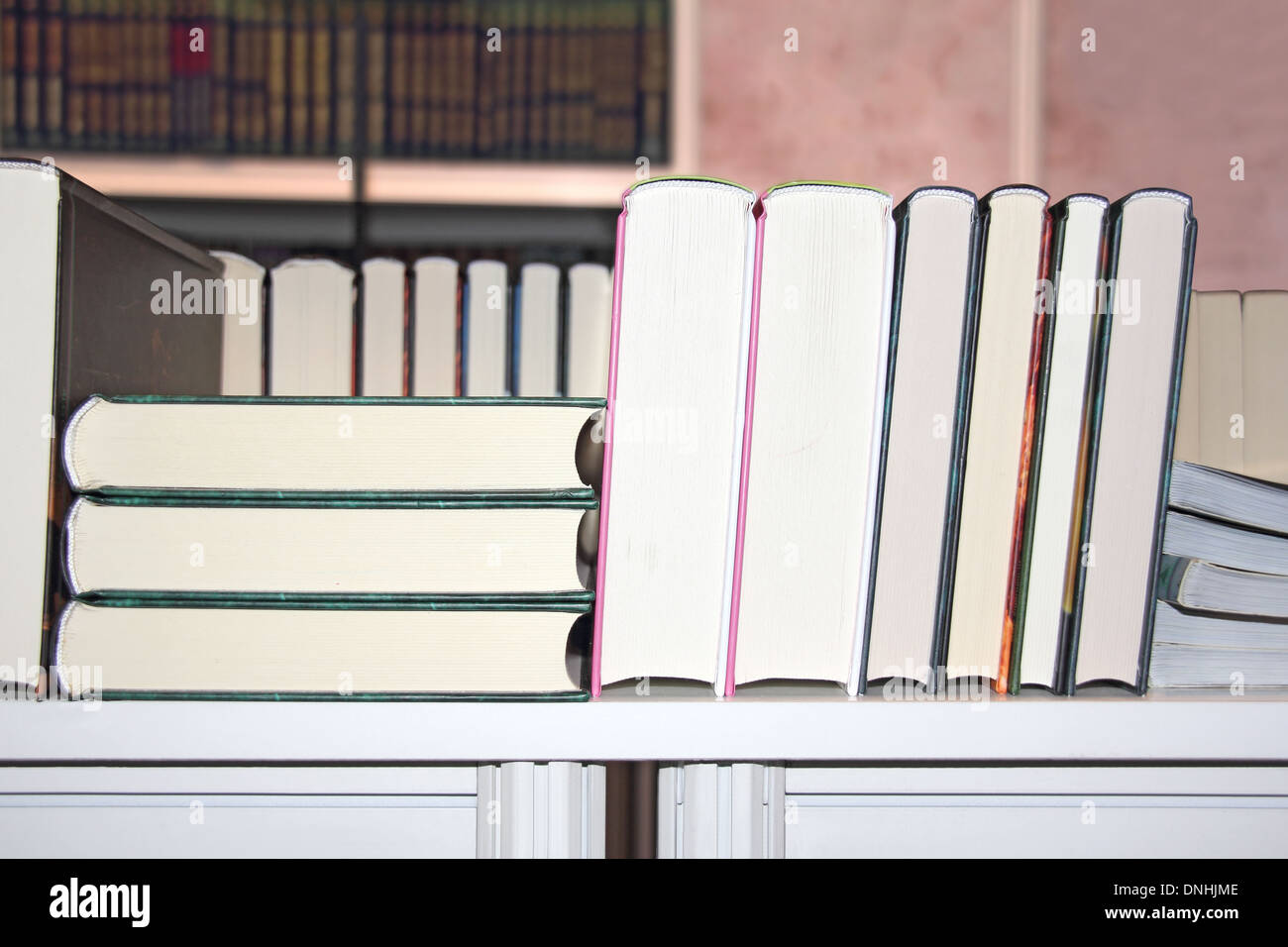 A pile of different books on a wooden shelf Stock Photo - Alamy