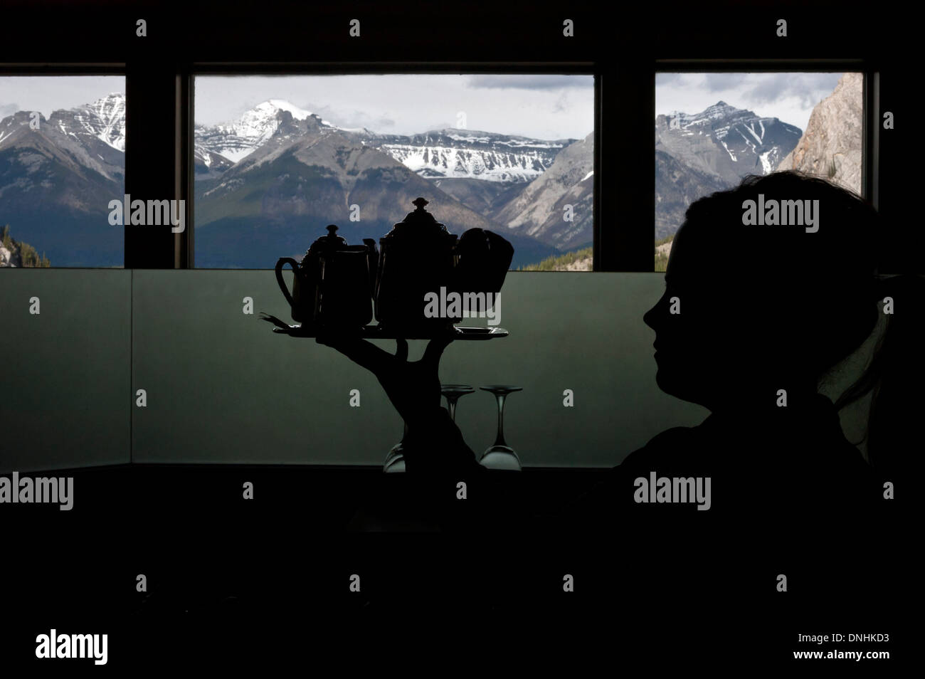 A silhouetted waitress at Banff Springs Hotel with views through to the ...