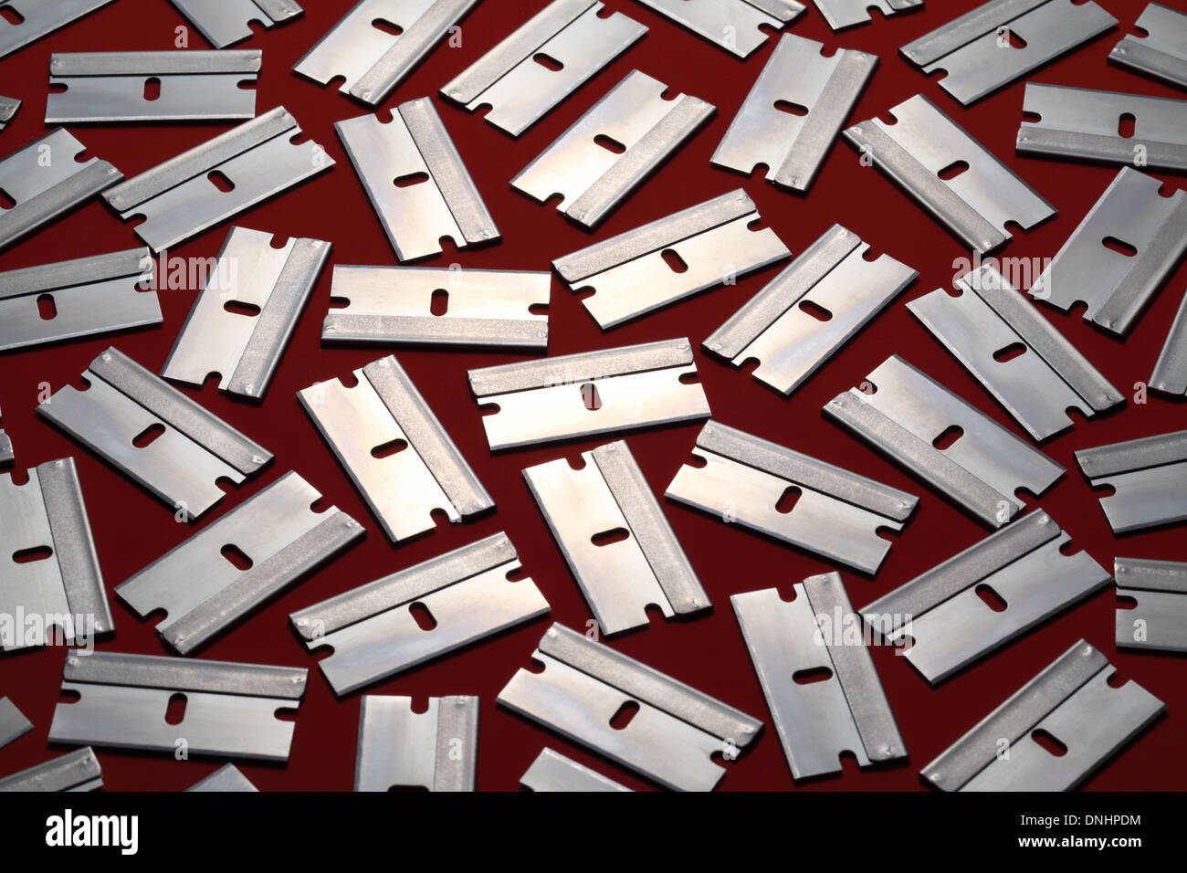 A pattern of many metal razor blades on a red background Stock Photo ...