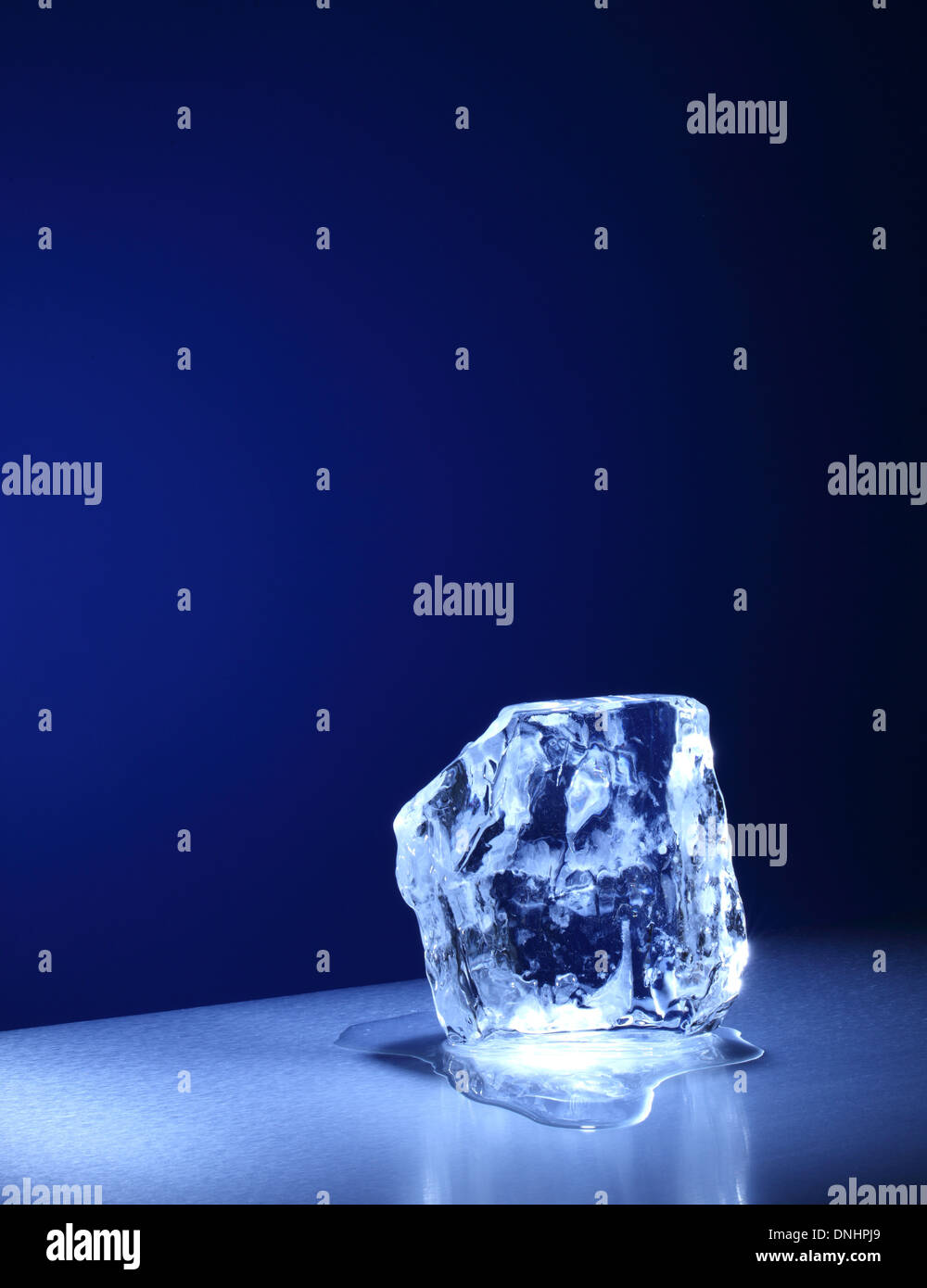 A large square cube / block of ice slowly melting Stock Photo - Alamy