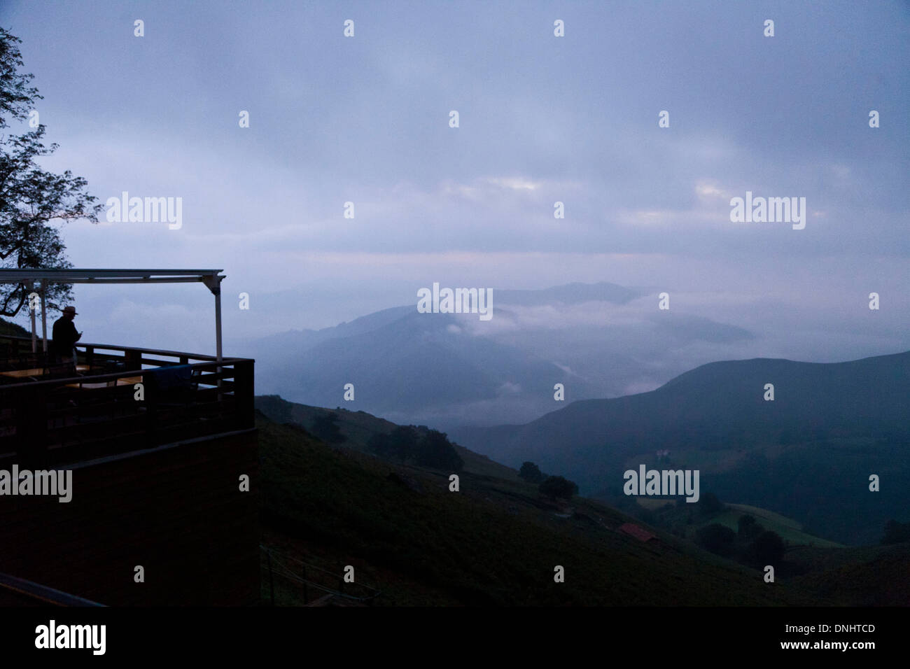 A man stands on a deck, at Orisson France, watching the sunrise before ...