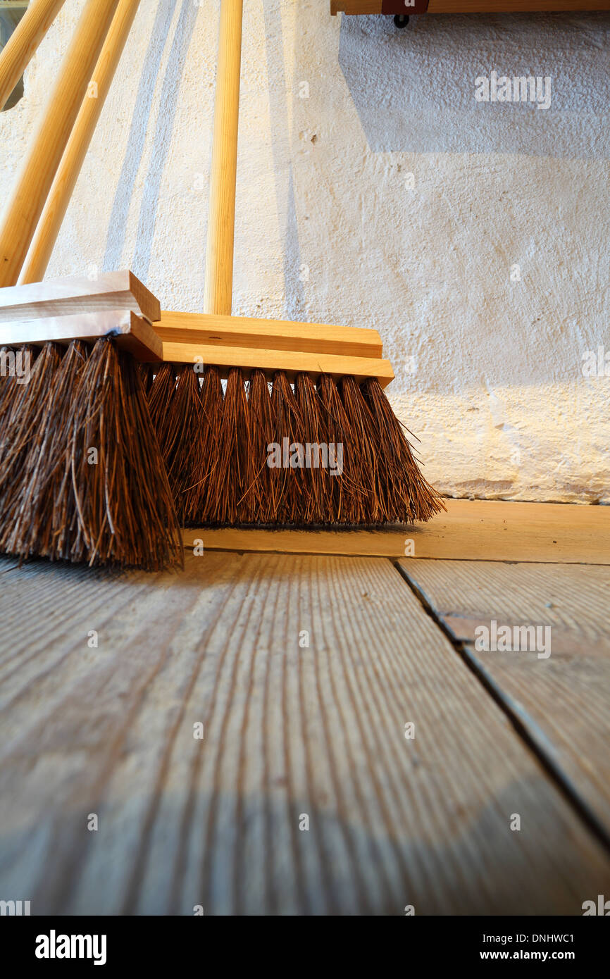 Close up large brooms for house work on old wooden floor of country ...