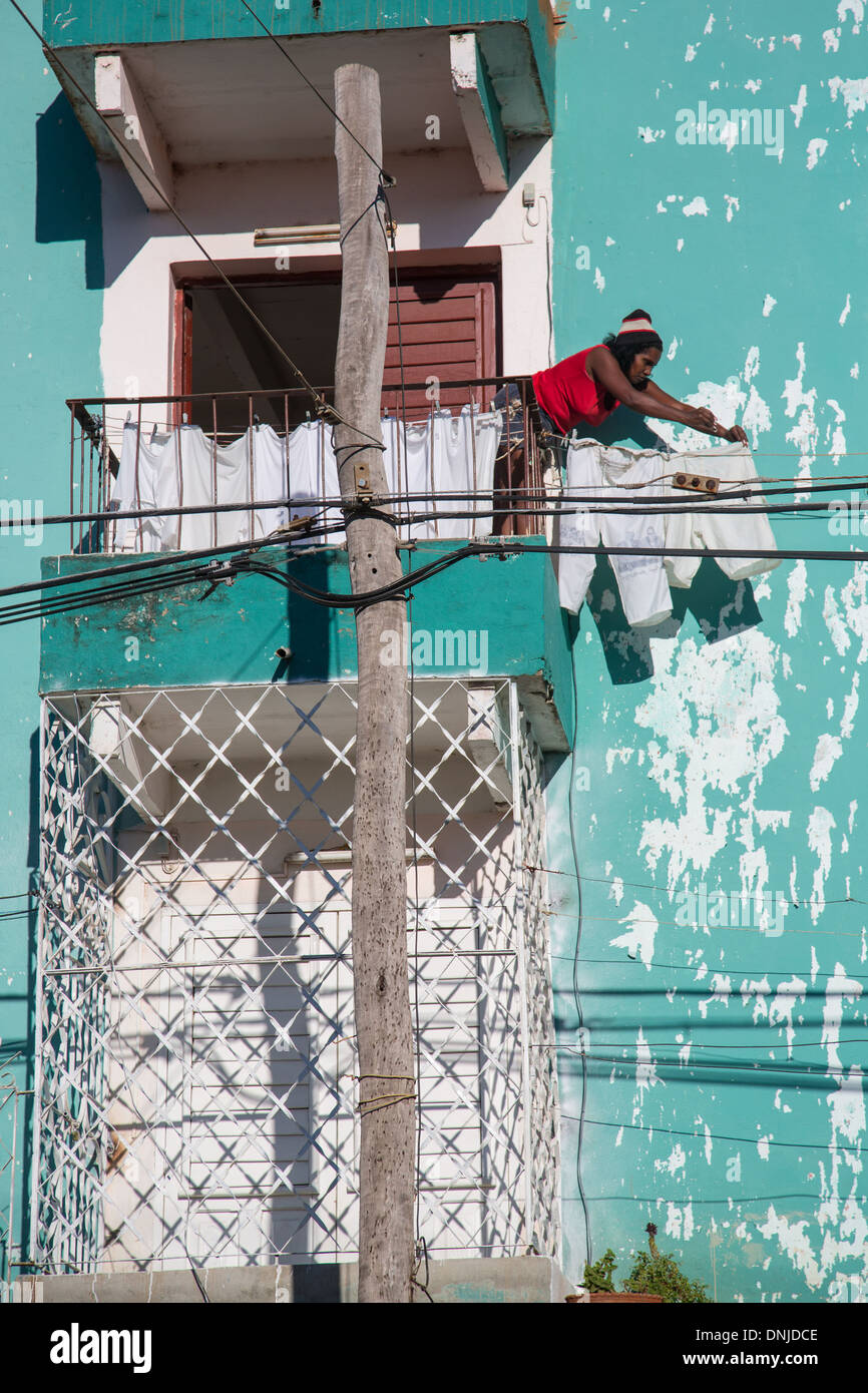 CUBAN WOMAN HANGING OUT HER LAUNDRY ON A COLOURFUL DECREPIT FACADE ...
