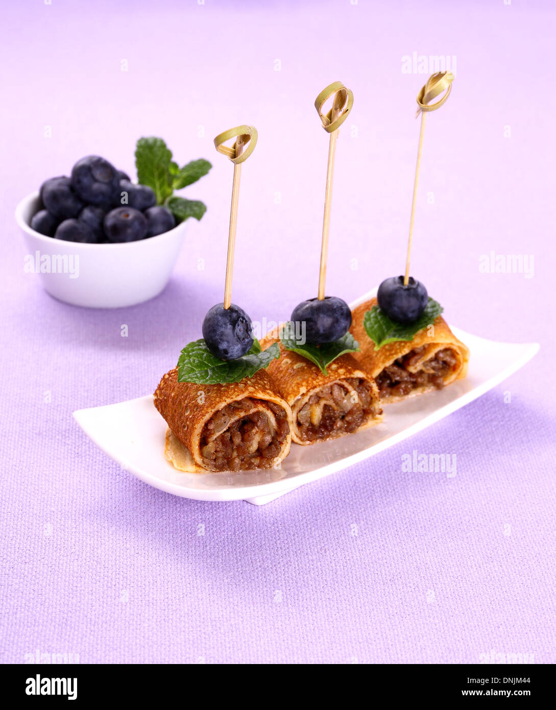 Pancake roll stuffed with minced meat on purple background as snack ...