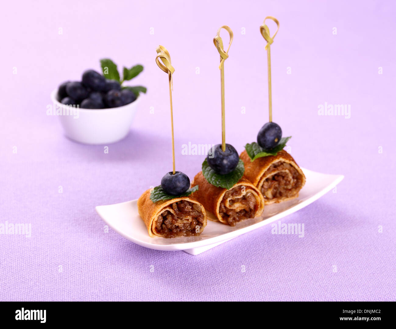 Pancake roll stuffed with minced meat and blueberries, close up Stock ...