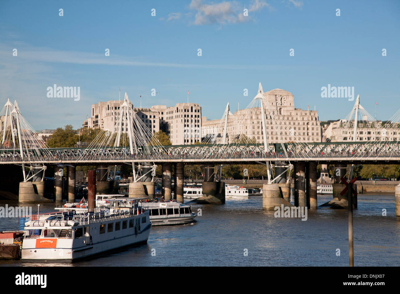 View of Hungerford Bridge with tourist boats, a Golden Jubilee Bridge ...