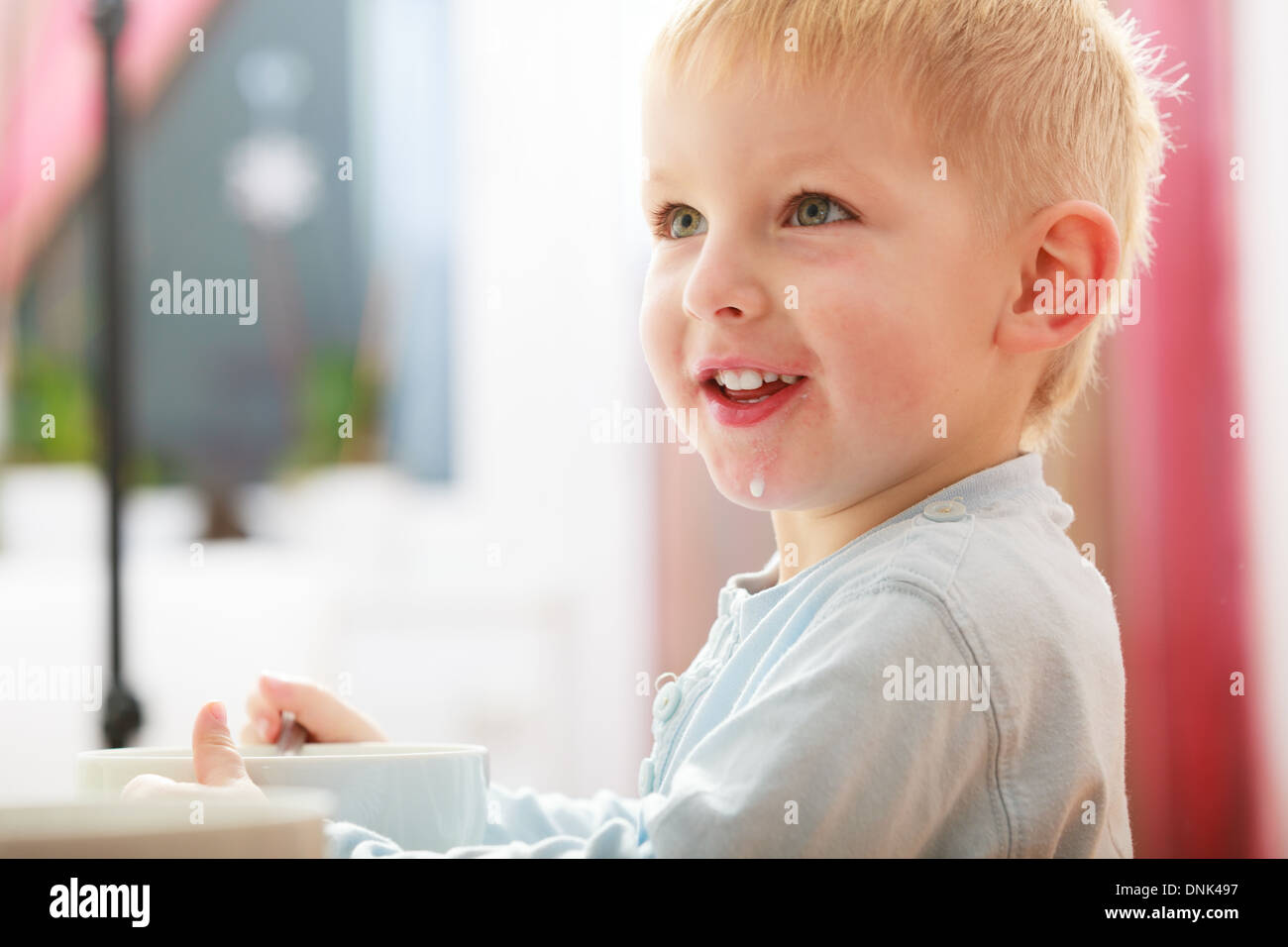 Blond boy kid child eating corn flakes breakfast morning meal at the ...