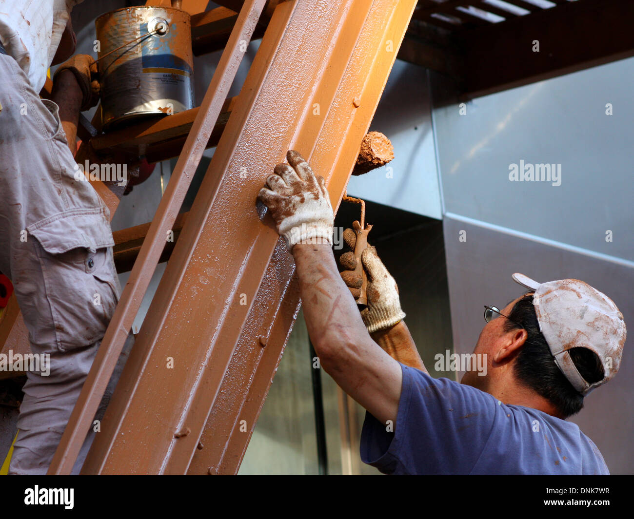 Painters with a paint roller painting an outdoor staircase in a messy ...