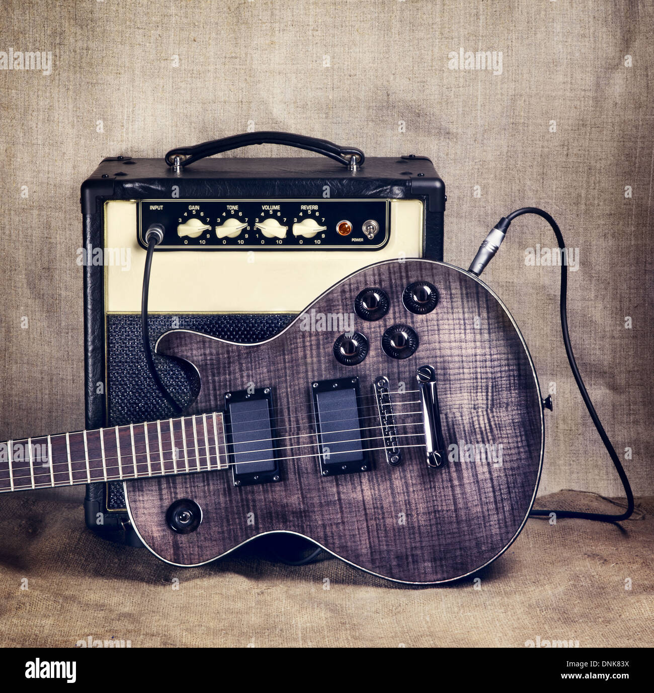 black electric guitar and amplifier on brown canvas background Stock ...