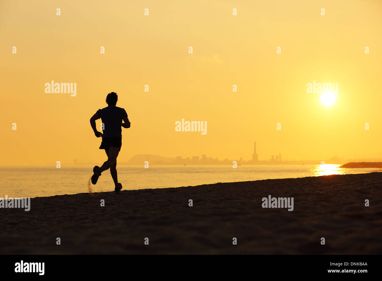 Silhouette of man running on beach at sunset hi-res stock photography ...