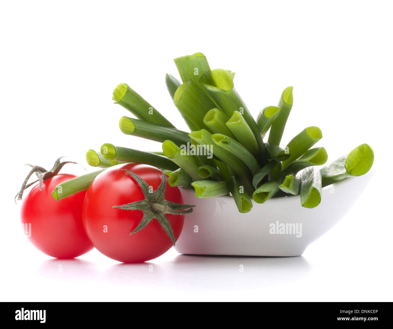 Spring onions and cherry tomato in bowl isolated on white background ...