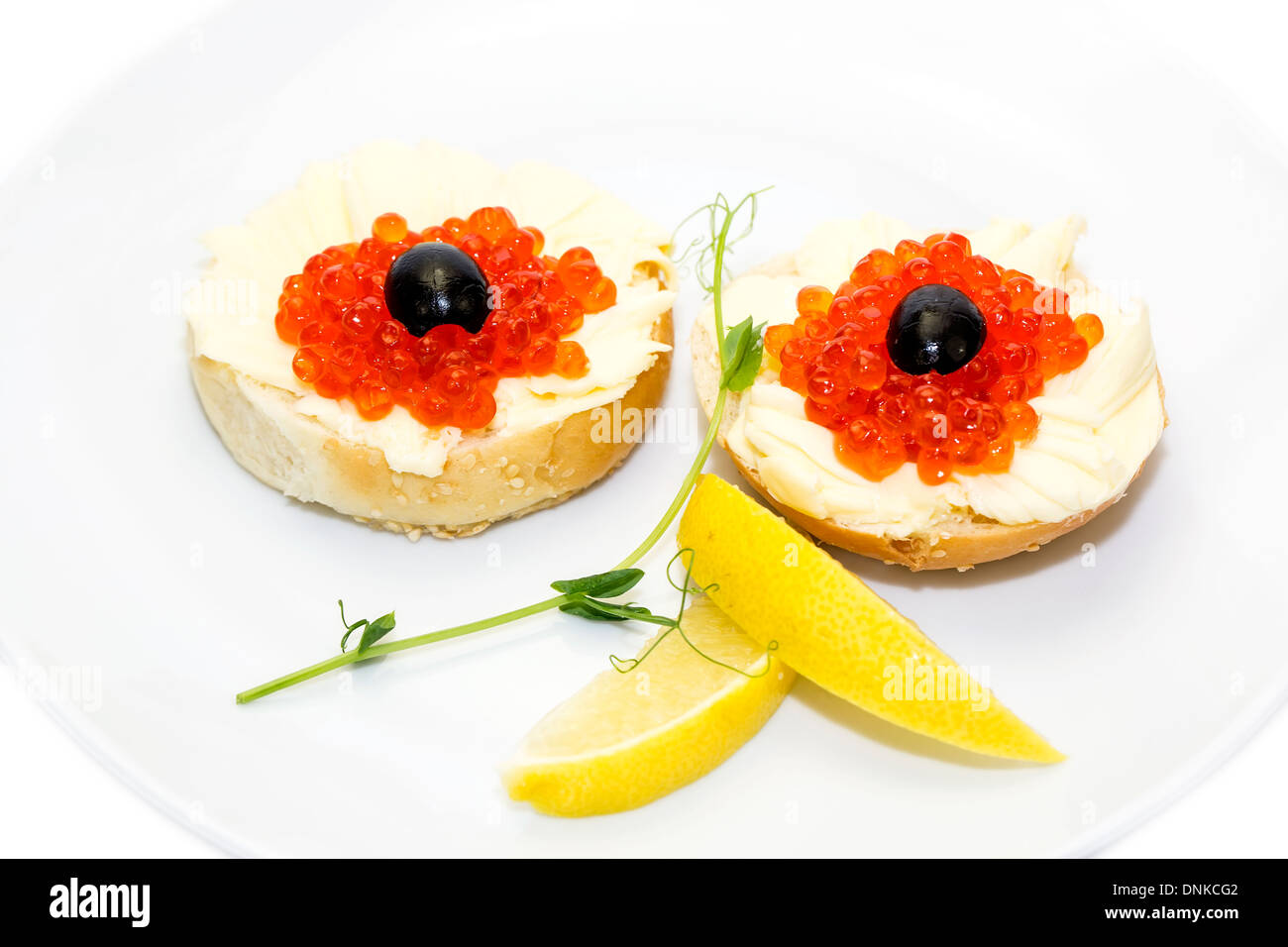 canape with red caviar and lemon on white background Stock Photo - Alamy