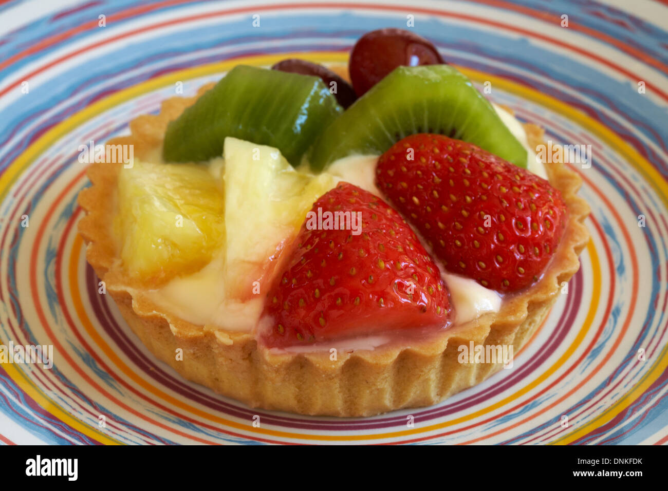 mixed fruit tart set on striped plate Stock Photo - Alamy