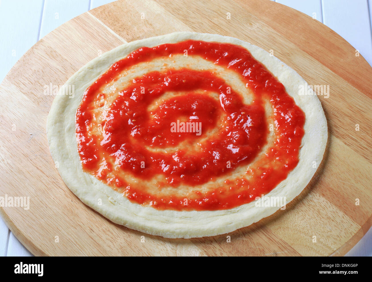 Tomato puree spread on raw pizza dough Stock Photo - Alamy