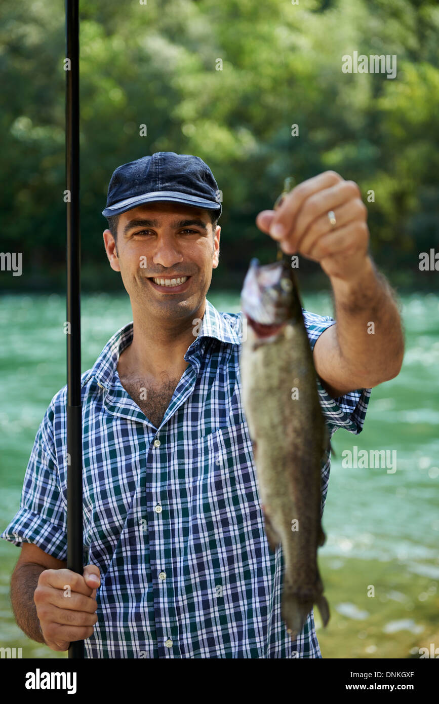 mid adult fisherman on holidays on river, relaxing and fishing trout ... mid adult fisherman on holidays on river, relaxing and fishing trout ...