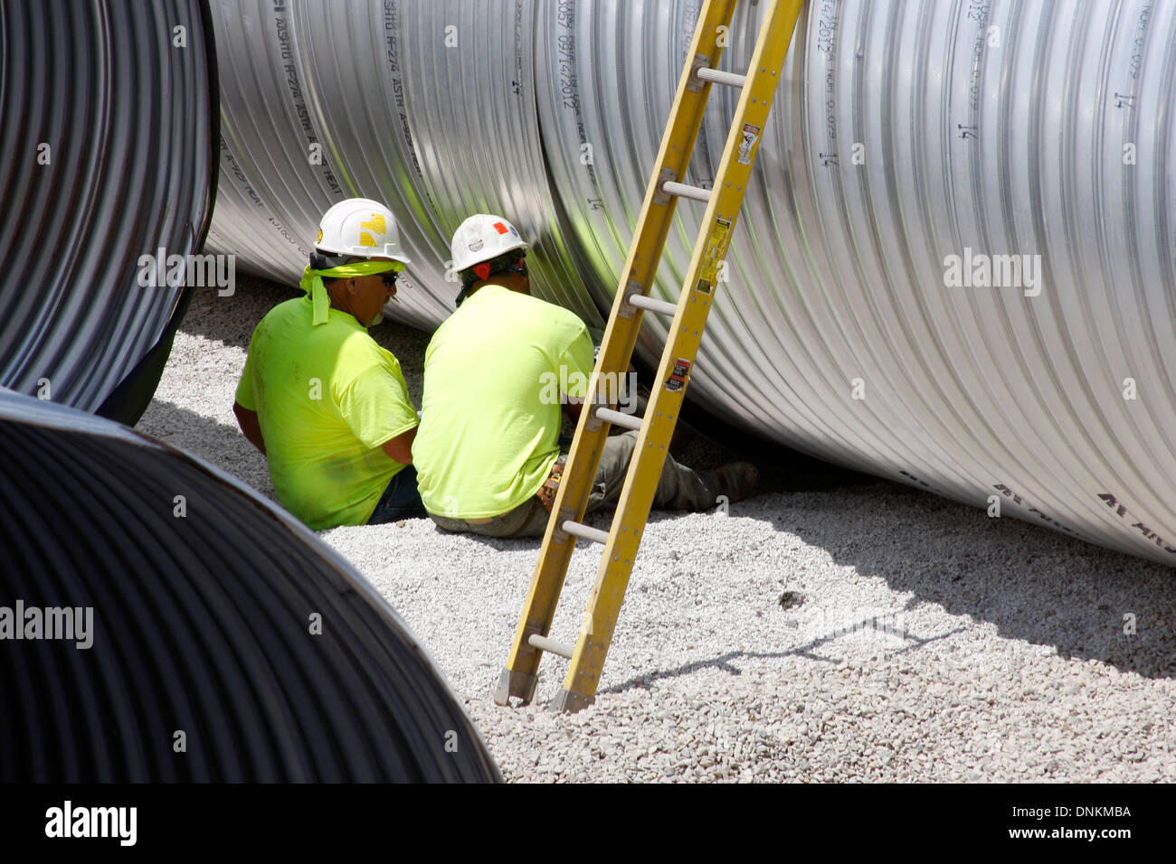 Two construction workers working on steel pipes Stock Photo - Alamy