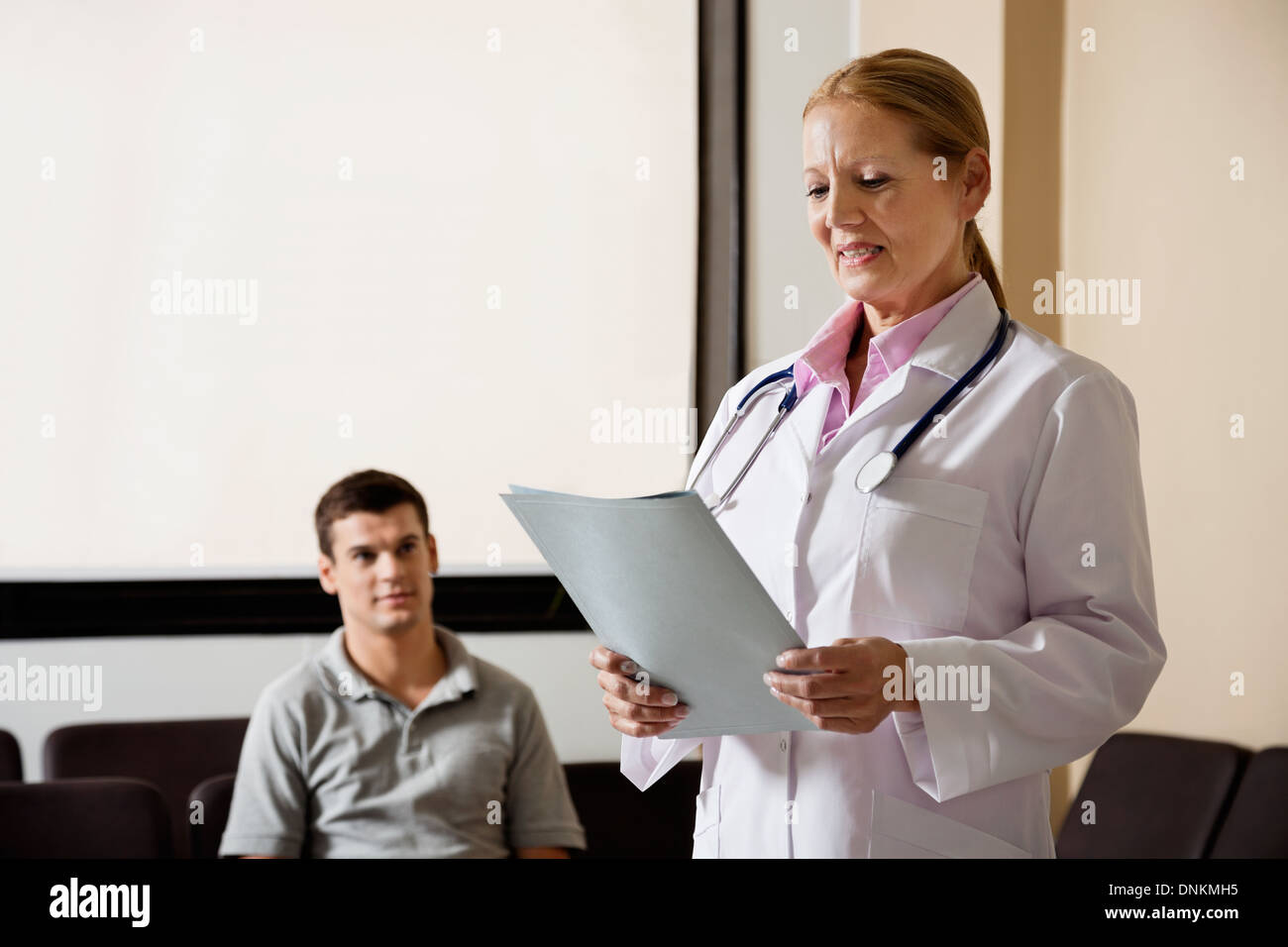 Female Doctor Looking At File Stock Photo - Alamy