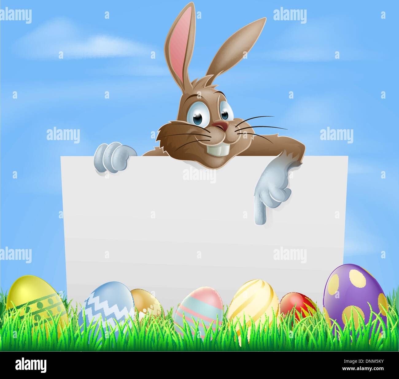 Easter bunny pointing at blank sign with painted chocolate Easter eggs ...