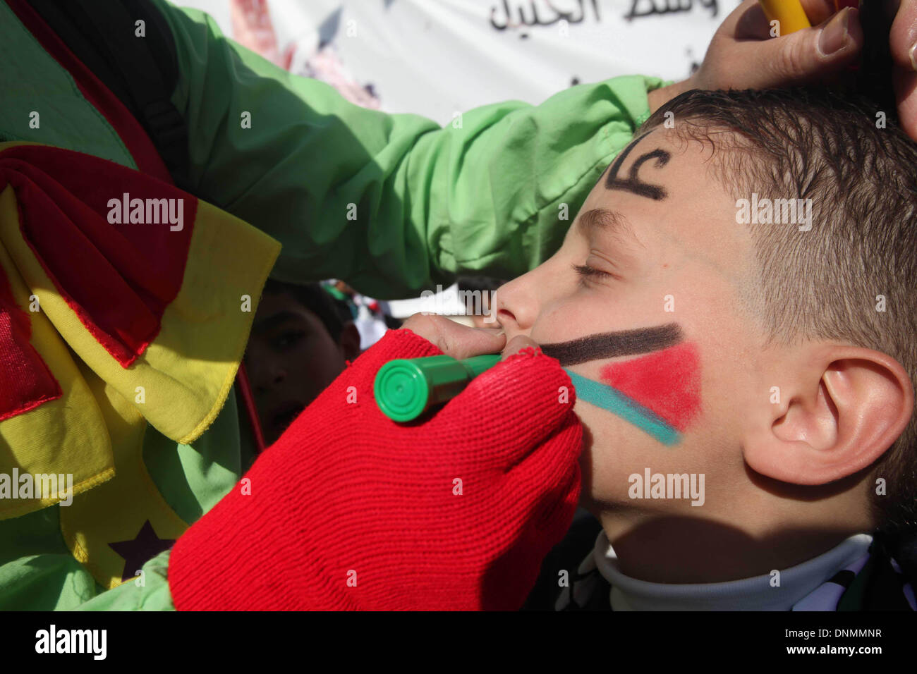 Hebron, West Bank, . 2nd Jan, 2014. A child has his face painted with ...