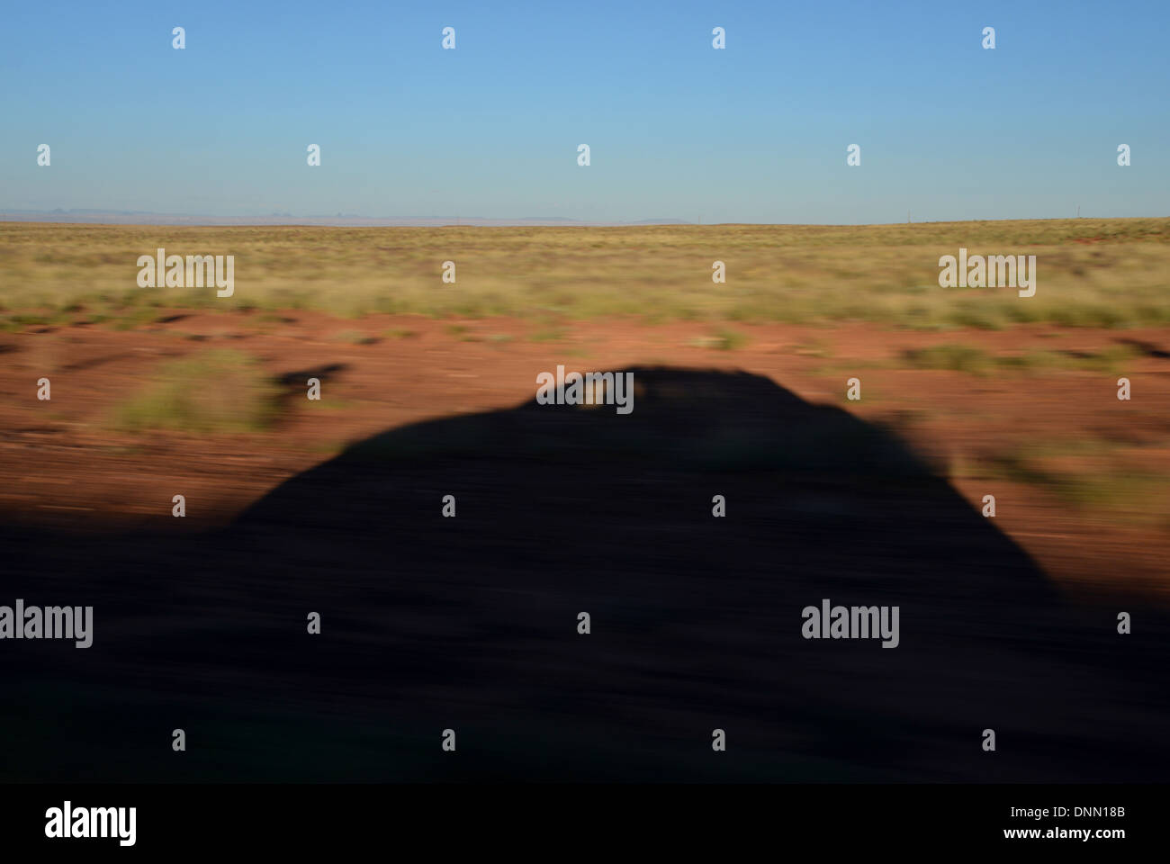 Car shadow as it speeds along a desert road Stock Photo - Alamy