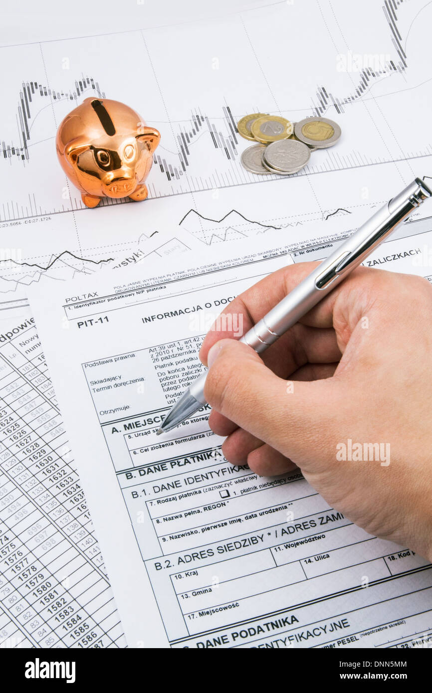 Man hand filling PIT-11 income tax forms with piggybank and coins Stock ...