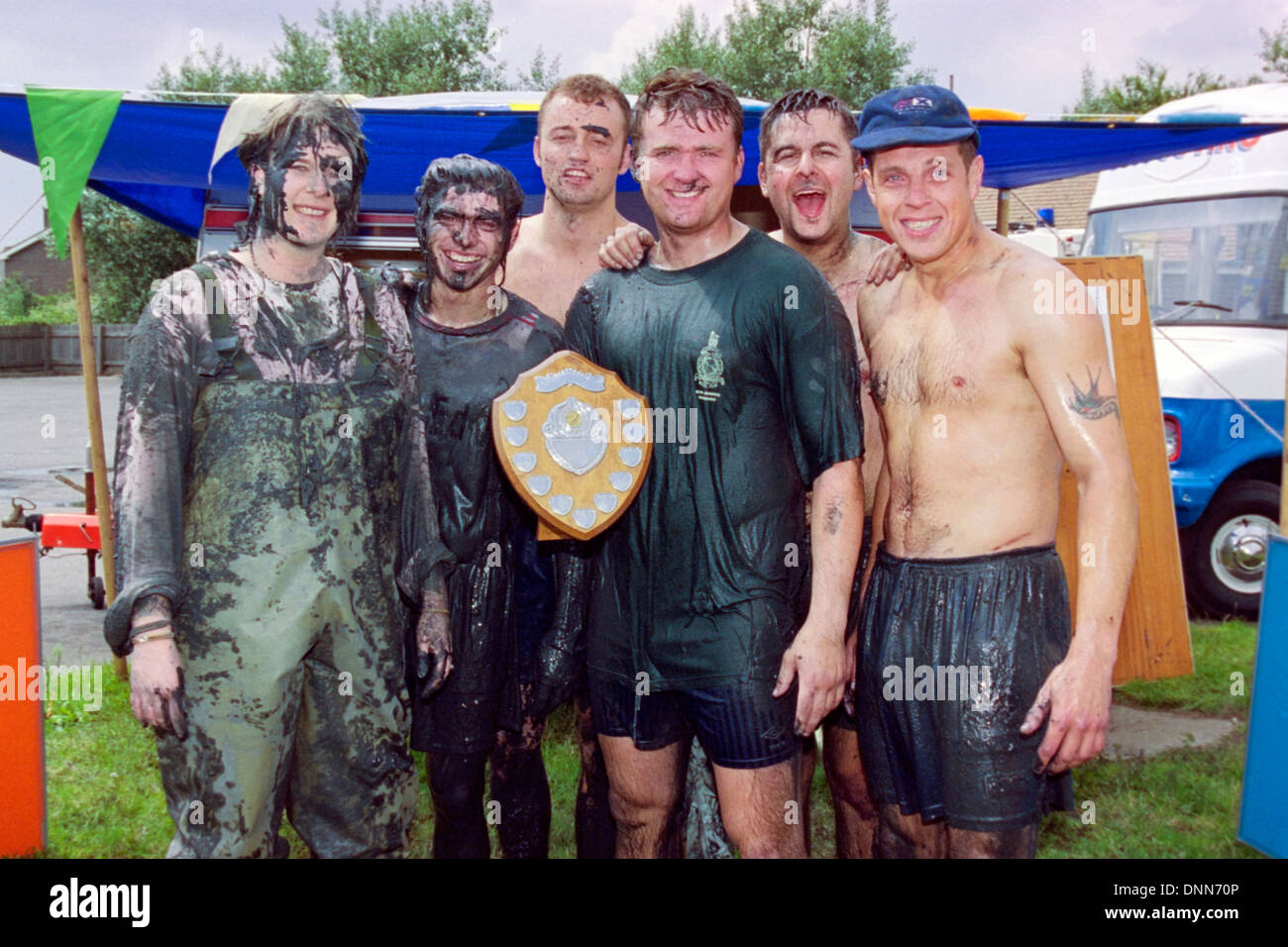 happy winners pose with trophy after traditional game of mud football ...