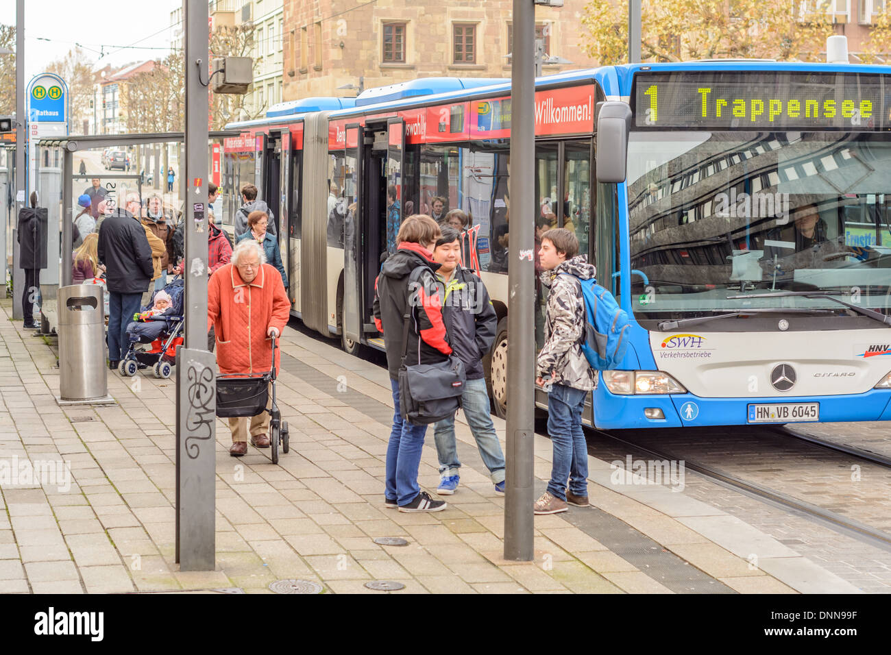 Articulated bus (bendy bus) waiting at a bus stop to pick up passengers ...