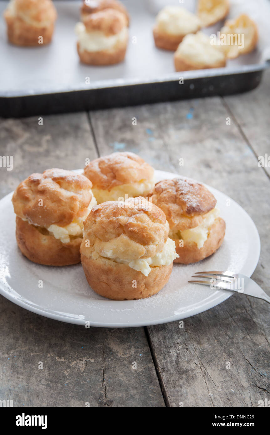 Profiteroles on a plate on wooden background Stock Photo - Alamy