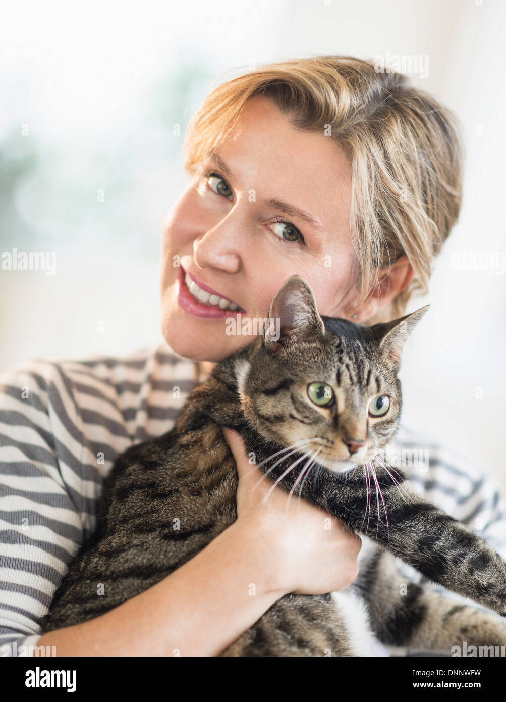 Portrait of woman hugging cat Stock Photo - Alamy
