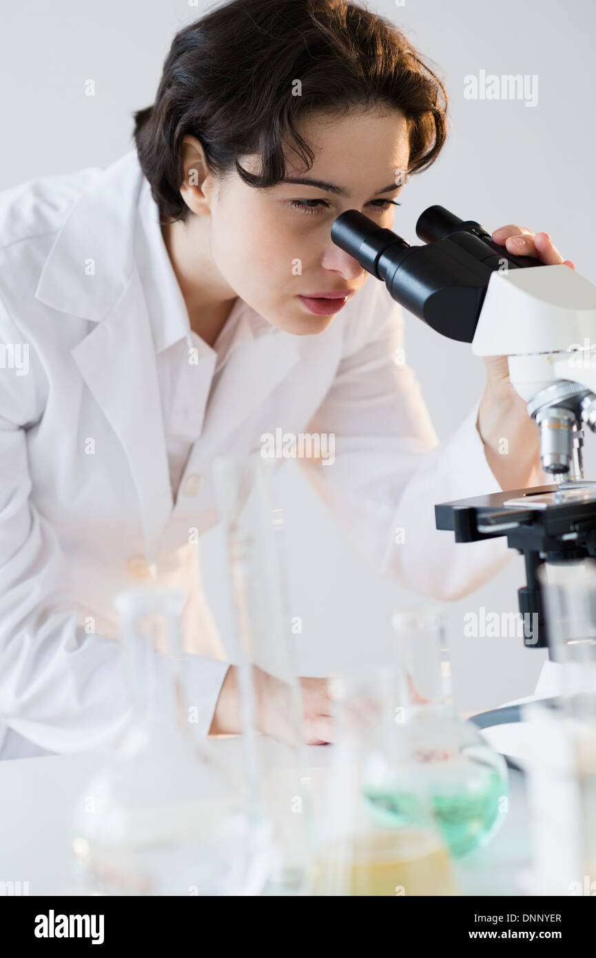 Scientist looking through microscope Stock Photo - Alamy