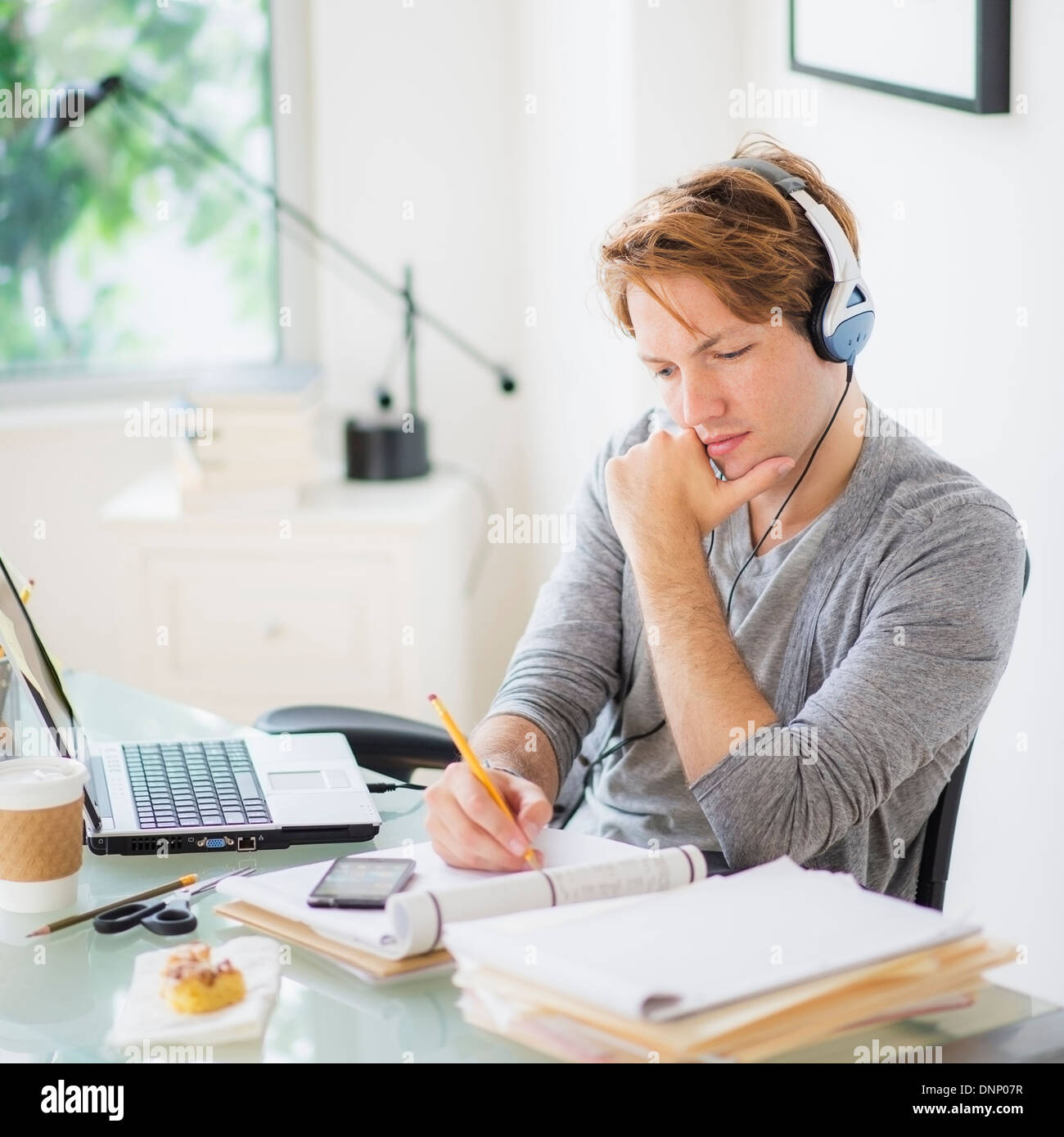 Man multi-tasking in home office Stock Photo - Alamy
