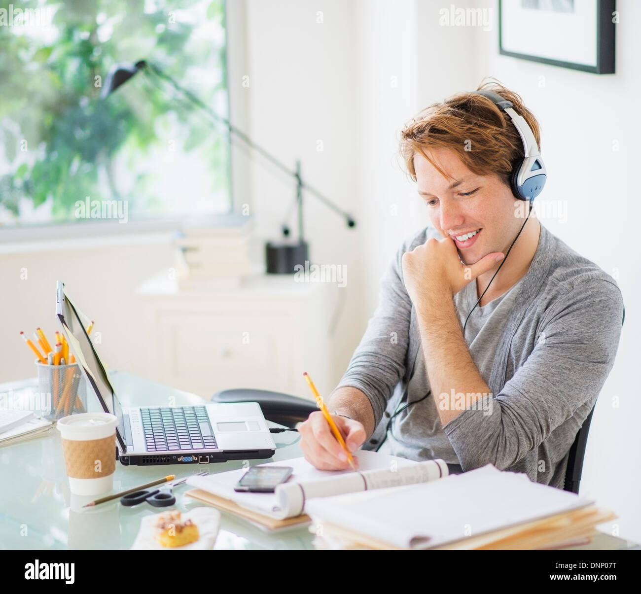 Man multi-tasking in home office Stock Photo - Alamy