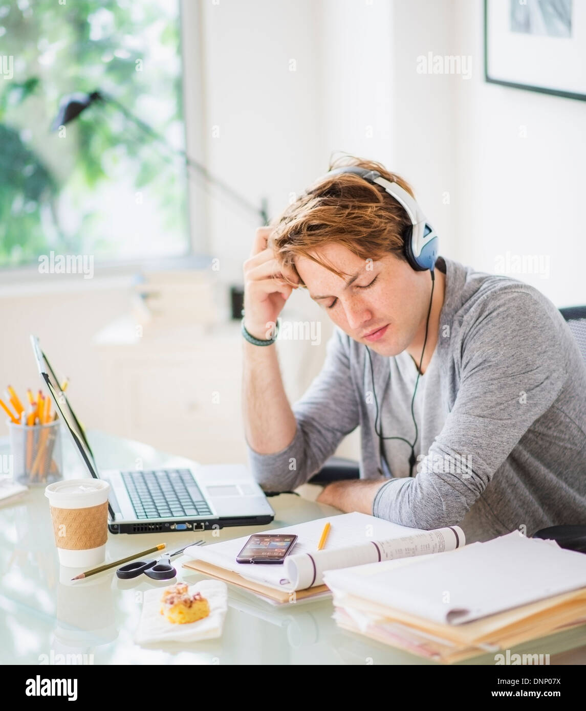 Man listening to music in home office Stock Photo - Alamy