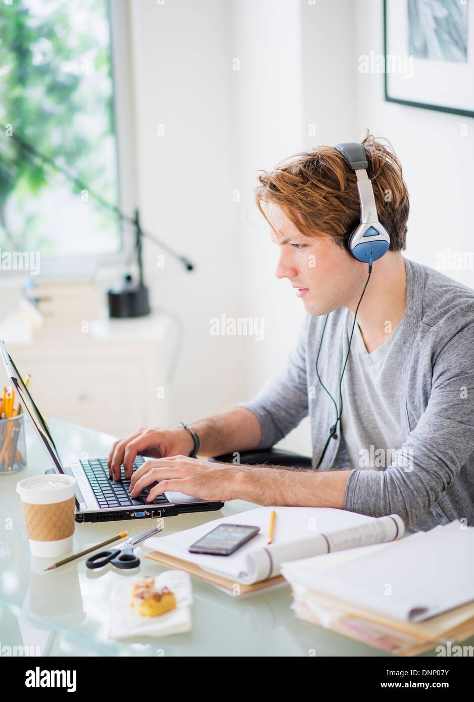 Man multi-tasking in home office Stock Photo - Alamy