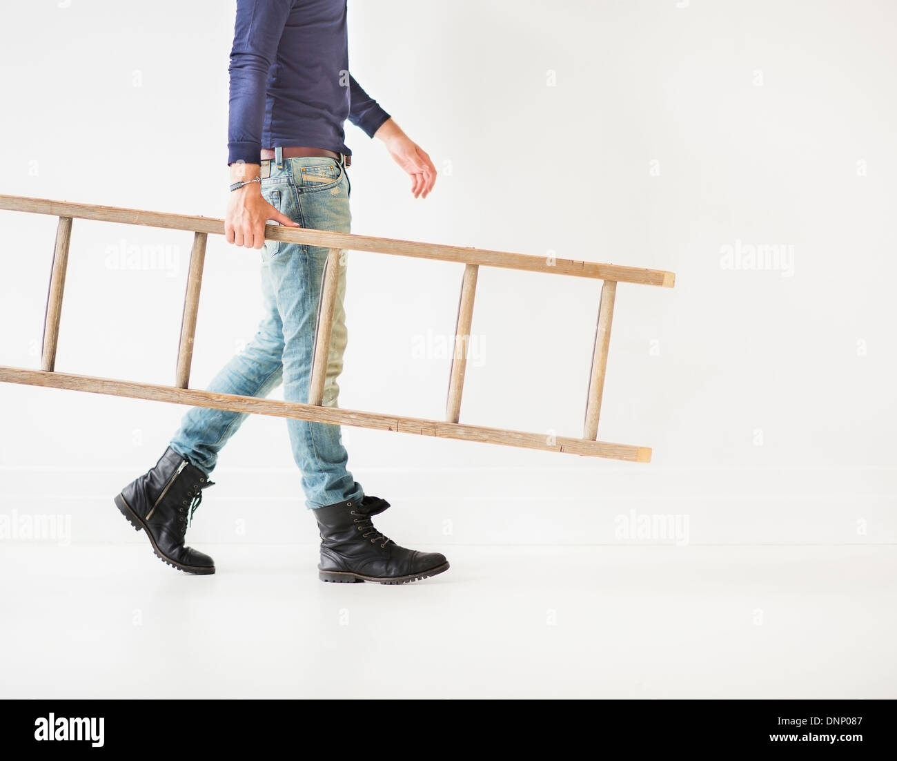 Low section of man carrying ladder Stock Photo - Alamy