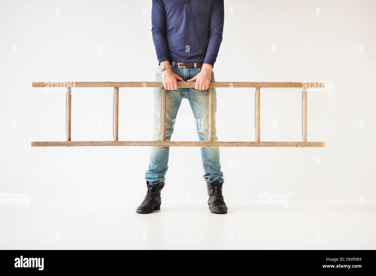 Low section of man carrying ladder Stock Photo - Alamy