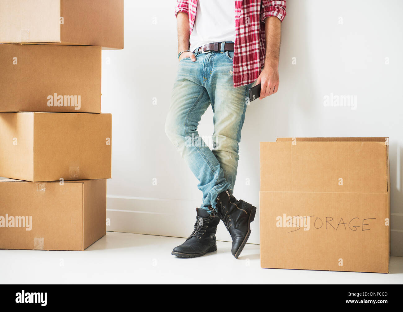 Low section of man next to stack of cardboard boxes Stock Photo - Alamy