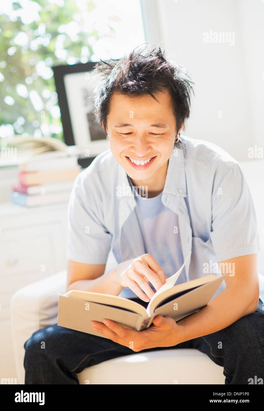 Teenage boy (16-17) reading book Stock Photo - Alamy